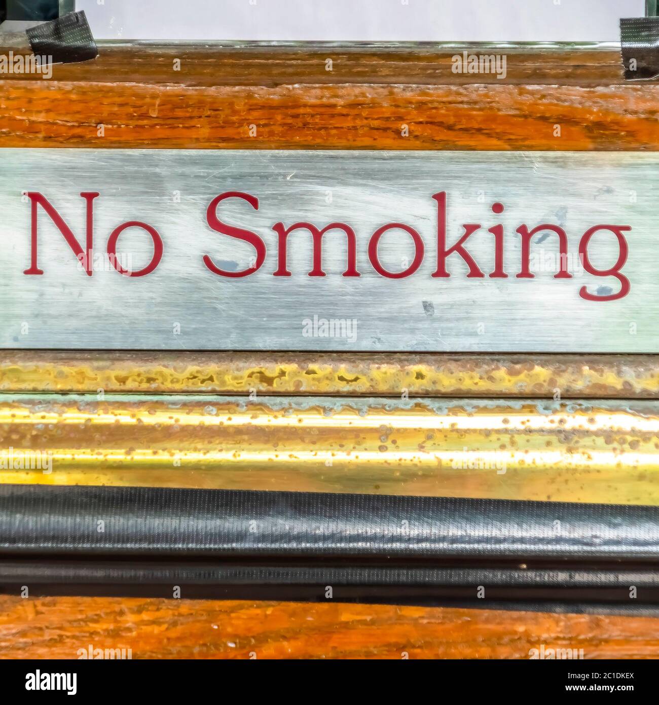 Square No Smoking sign above mail drop slot with black tape against ...