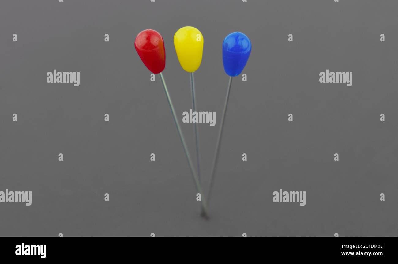 Three different colored brooches pin placed beside one another on a ...