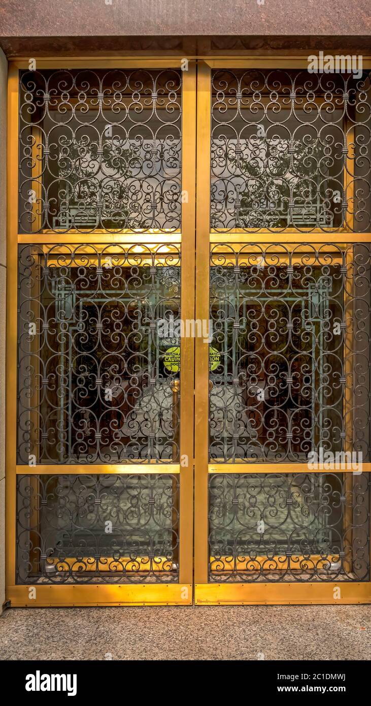 Vertical crop Decorative wrought iron door with gold frames in front of ...