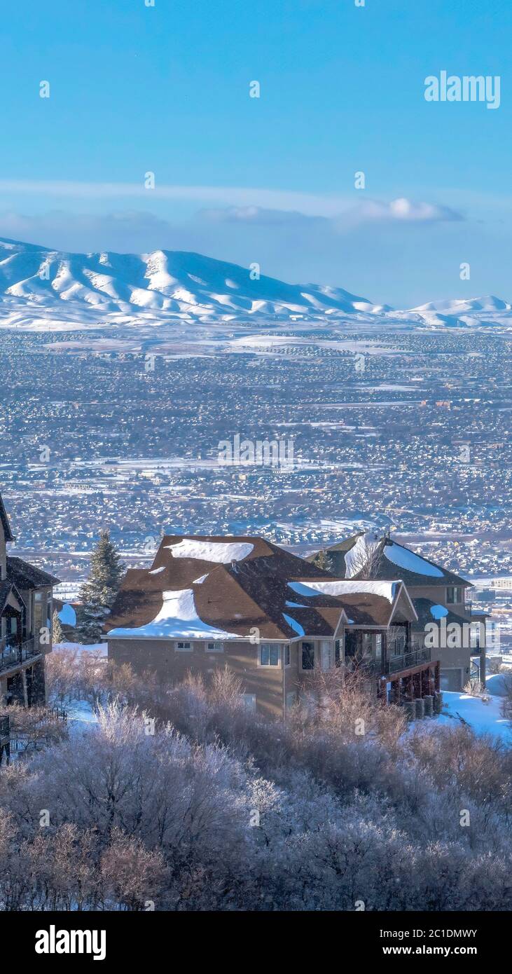 Vertical crop Snow falling on Wasatch Mountains with homes on frosted ...