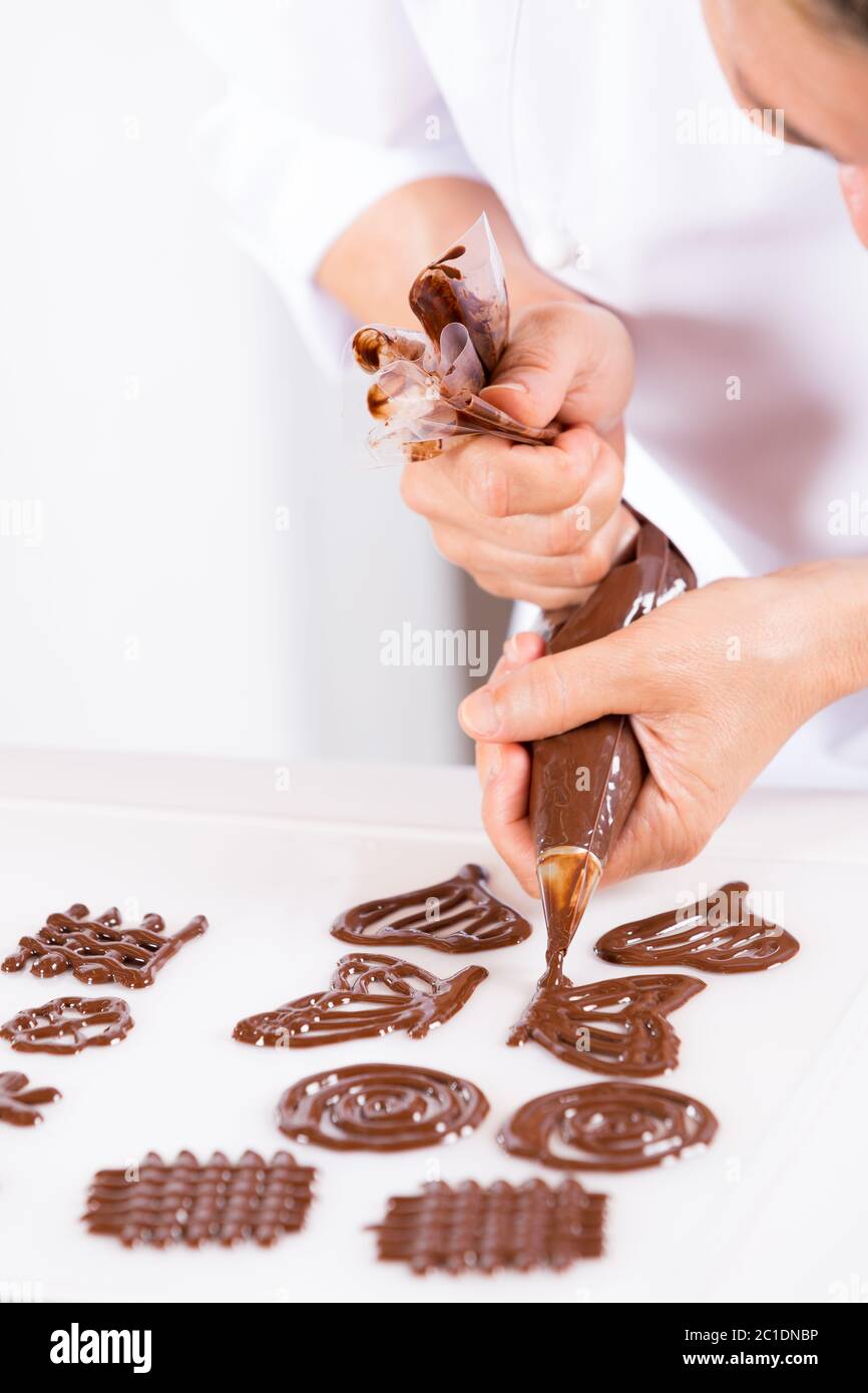 Chef making figures with chocolate to decorate a cake Stock Photo - Alamy