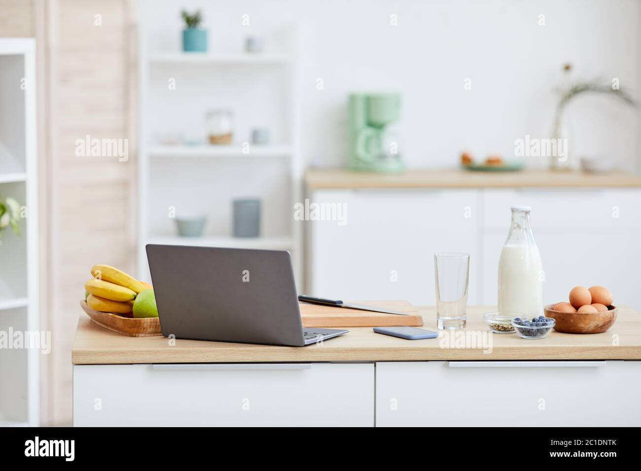 Image of kitchen table with fruits and laptop computer on it in ...