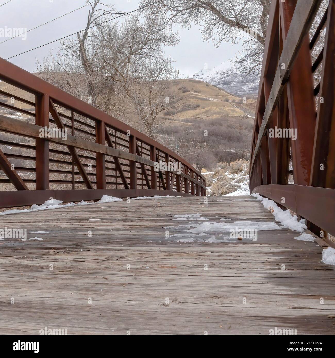 Square frame Bridge with metal railing and melting snow on the wooden ...