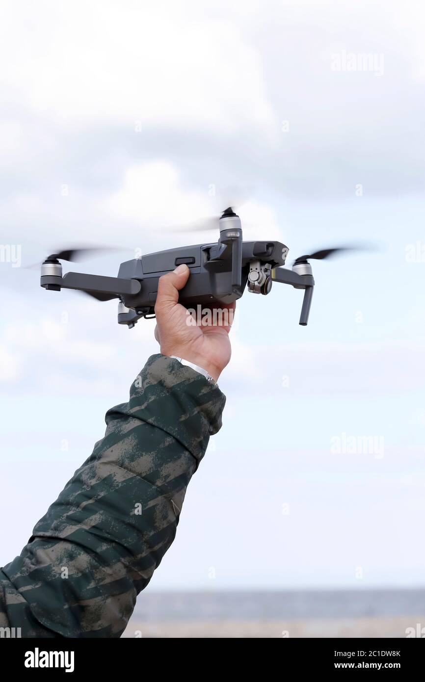 Hand catching drone aircraft in sky background, camera operator concept ...
