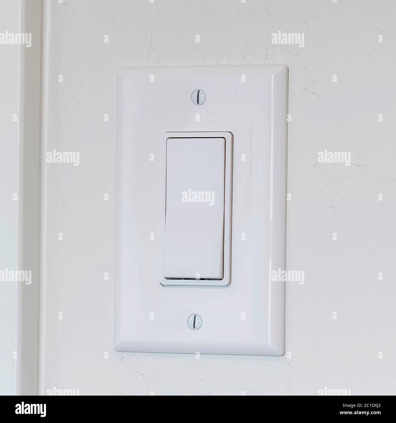 Square Indoor electrical light switch of home mounted on white wall ...