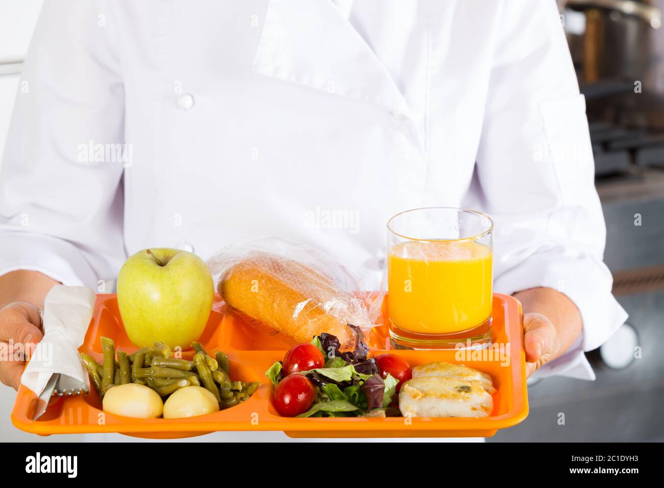 Cook in a school with a tray of food Stock Photo - Alamy
