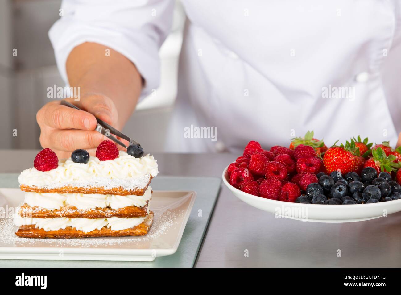 Pastry chef decorating with berries pie pastry Stock Photo - Alamy