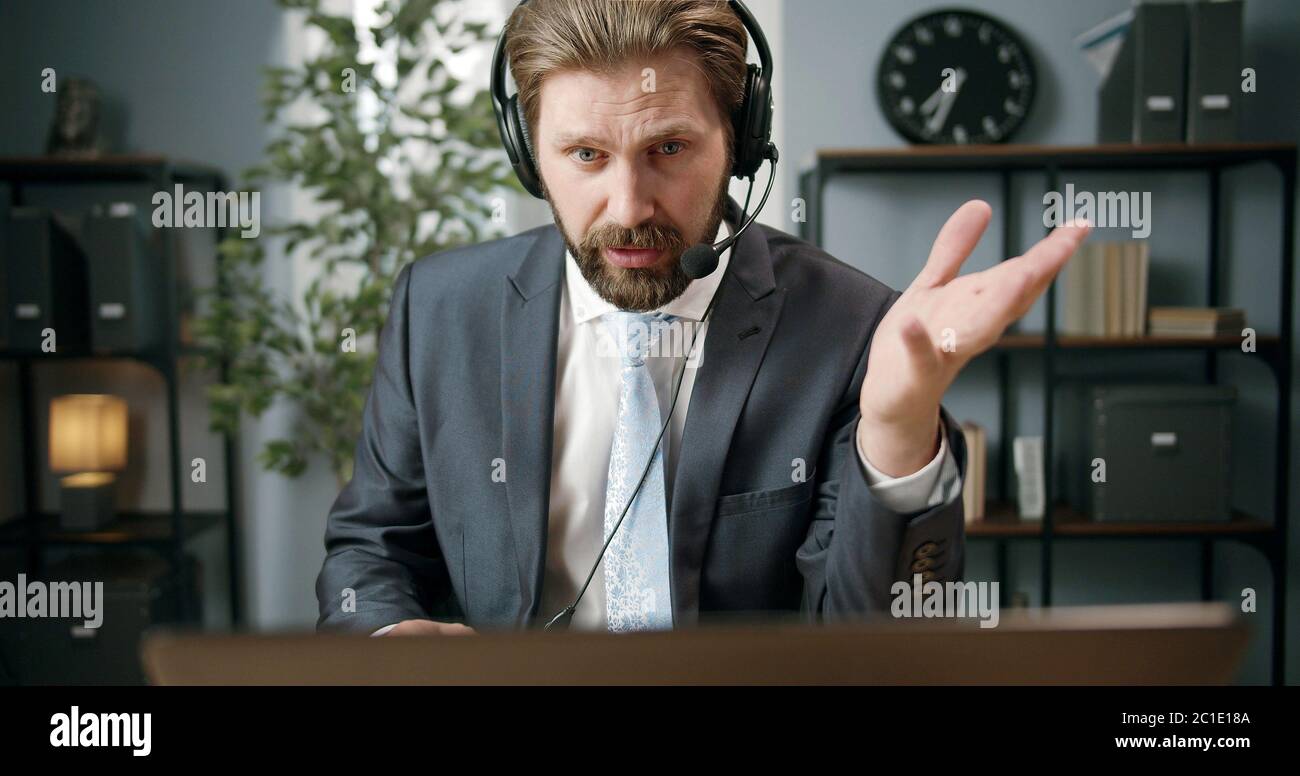 Businessman using headset to talk Stock Photo - Alamy