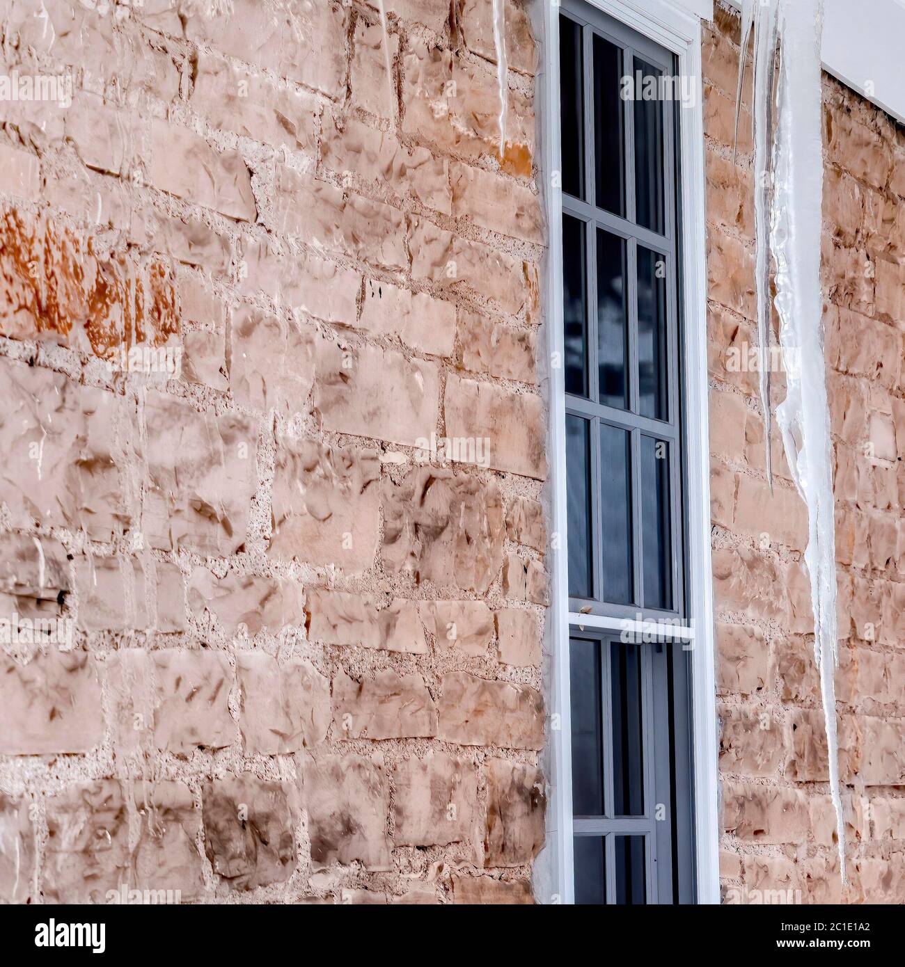 Square crop Sharp spiked icicles against windows and stone exterior ...