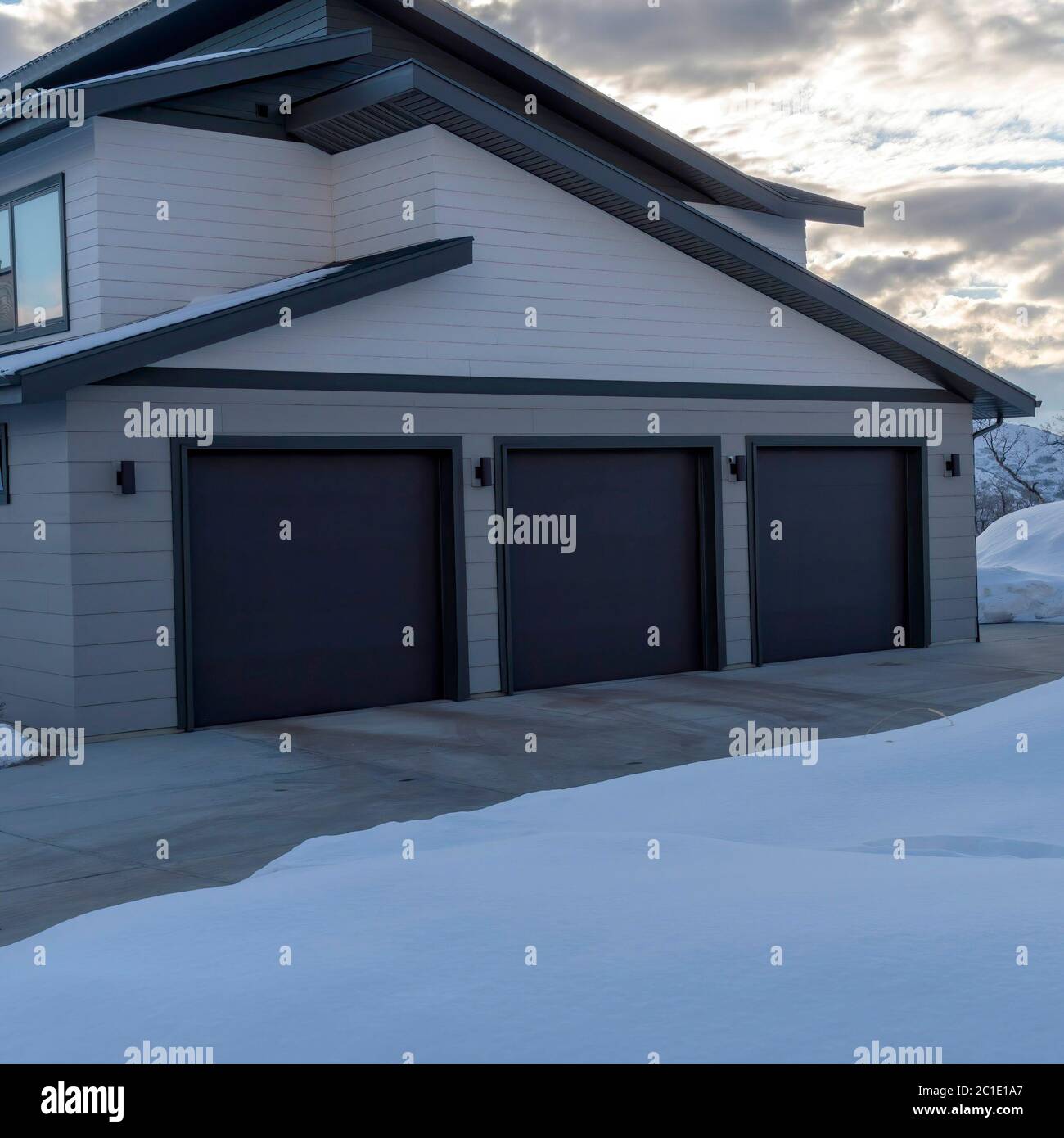 Square frame Home exetrior with paved driveway leading to the three ...