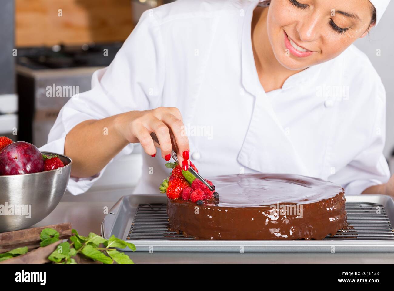 Pastry chef in the kitchen decorating a cake of chocolate Stock Photo ...