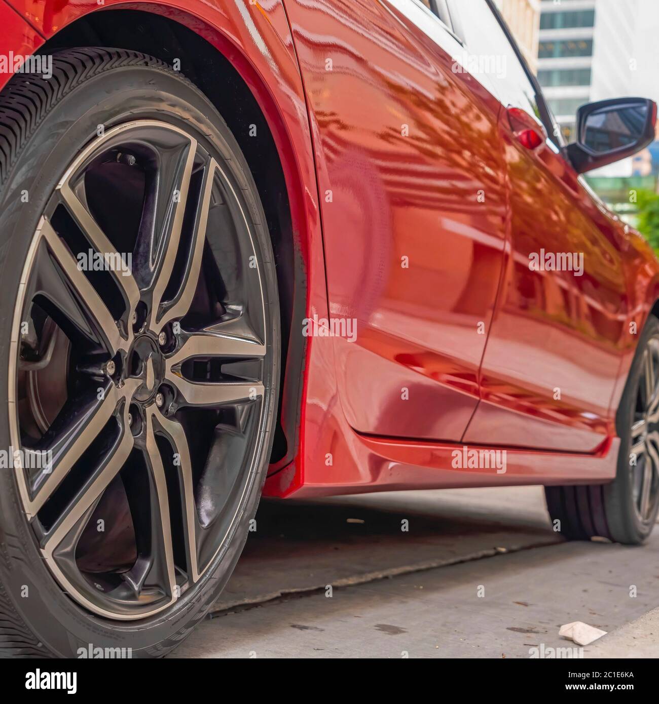 Square Shiny red car exterior with close up of the black rubber wheels ...