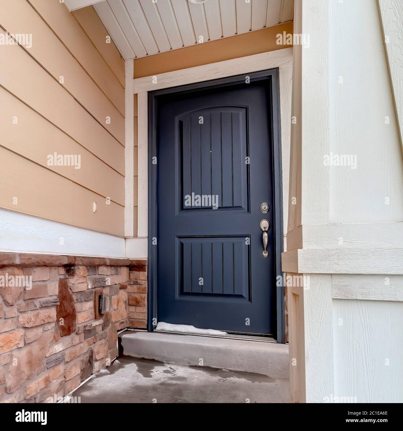 Square frame Home entrance with blue panel door and wall with stone ...