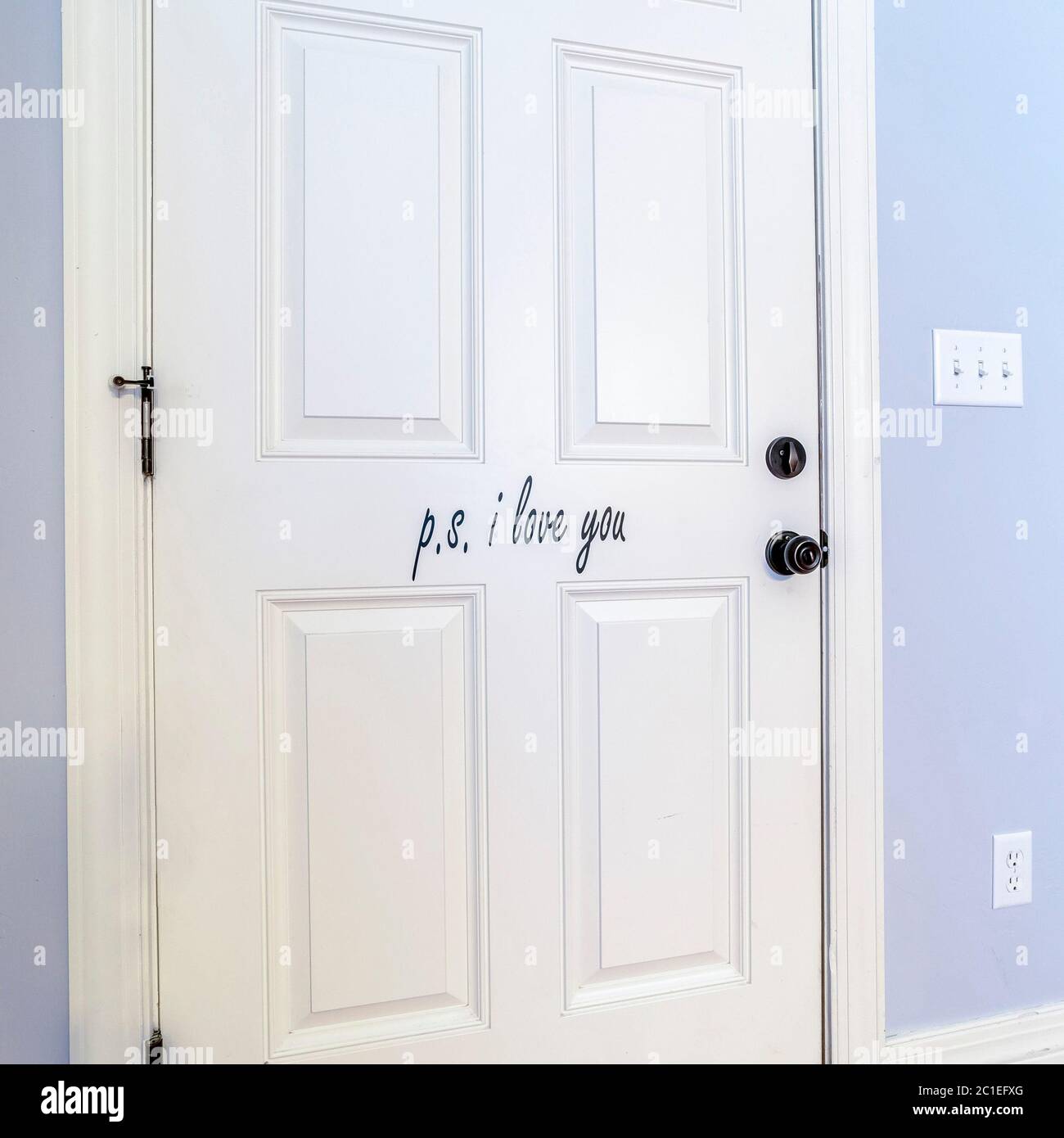 Square White interior wooden door in a blue wall Stock Photo - Alamy