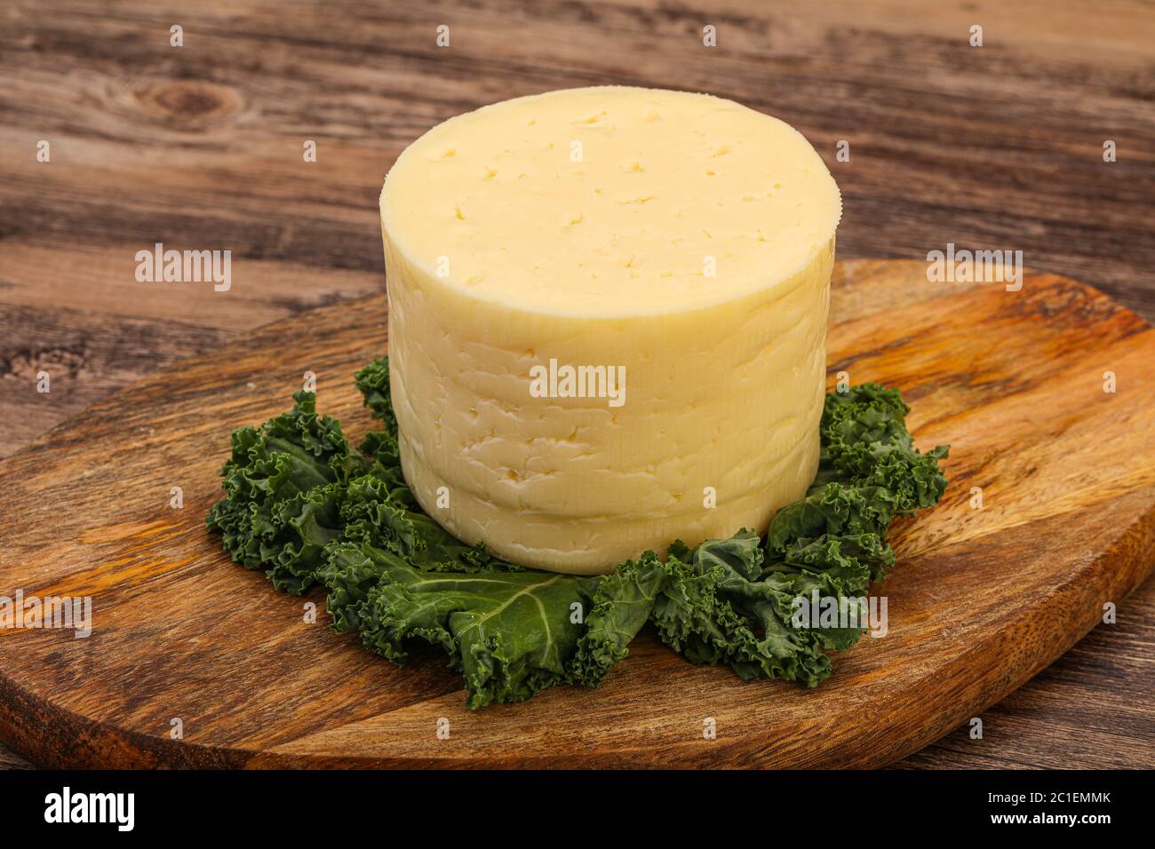 Yellow round dairy soft cheese piece Stock Photo - Alamy