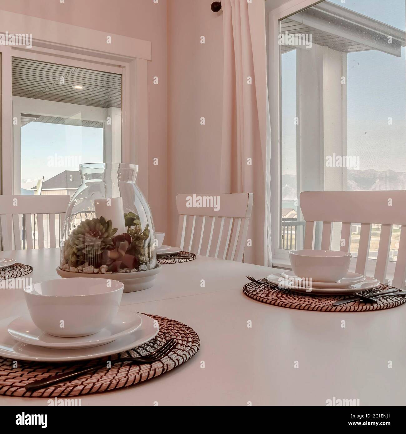 Square Dining table with tableware and woven placemat arranged around a ...