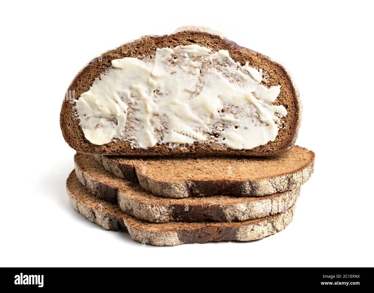 A slice of black rye bread spread with butter on a white background ...