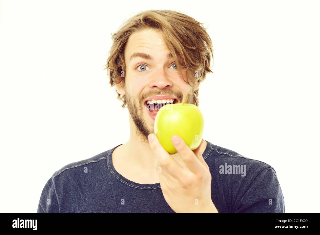 Man with happy face expression and smile holds juicy green apple in his ...