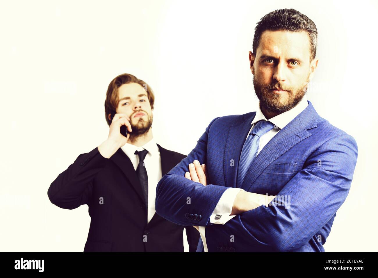 serious businessman in blue suit and man talking on phone isolated on ...