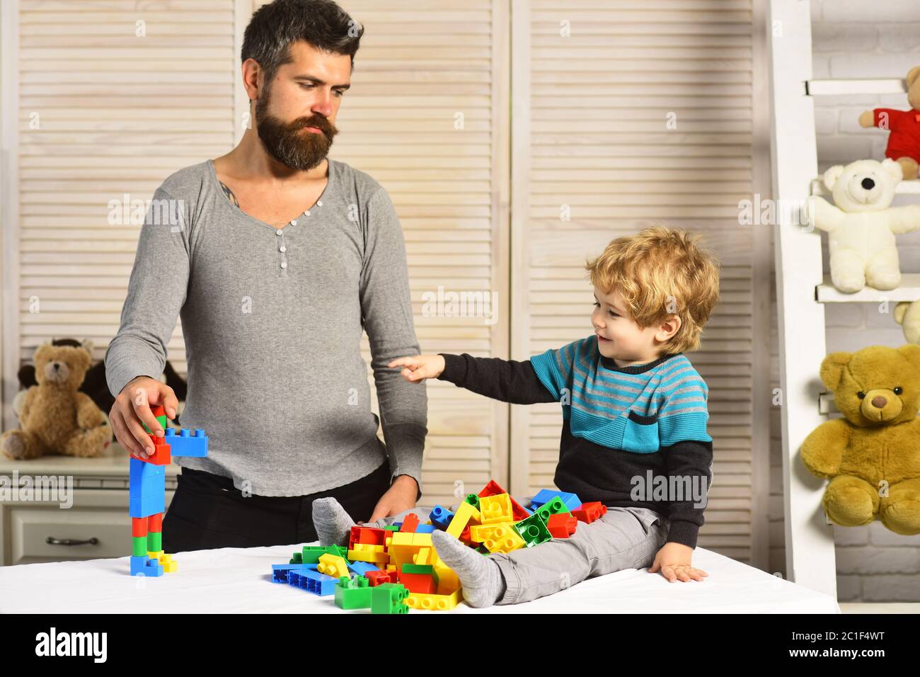 Dad and kid build of plastic blocks. Family and childhood concept ...