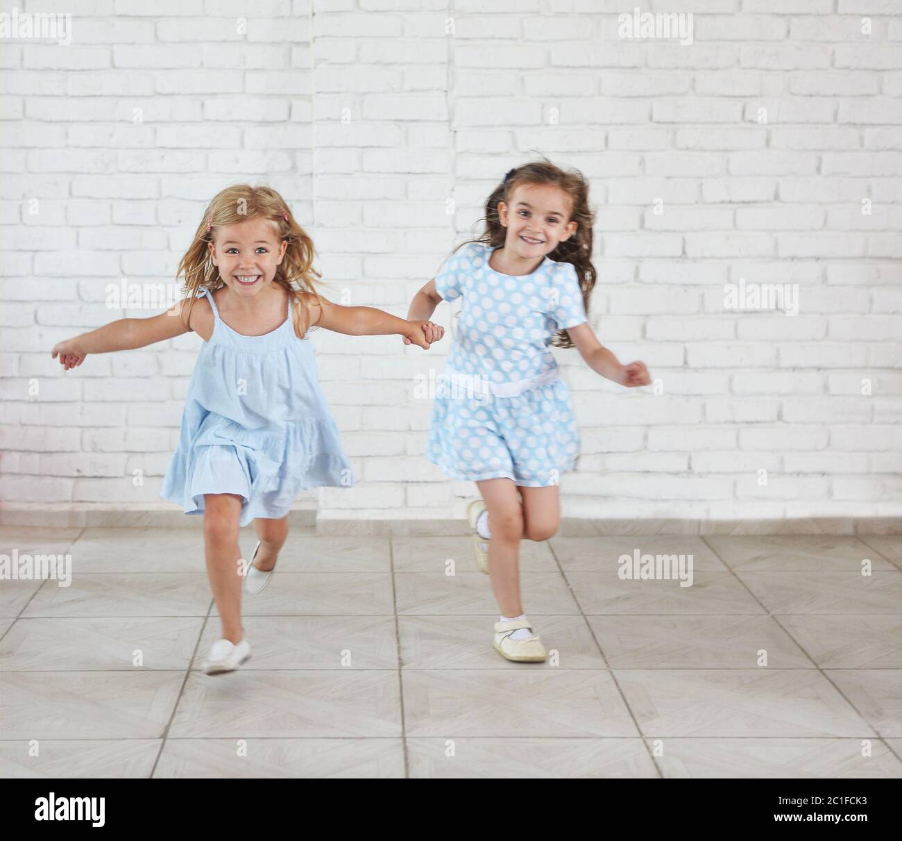 Two small girls playing indoors Stock Photo - Alamy
