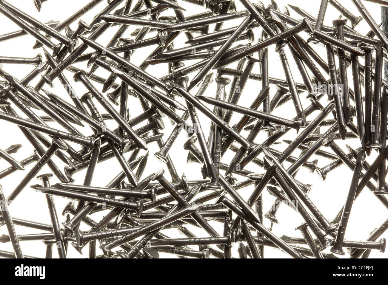 Many steel nails on white background Stock Photo - Alamy