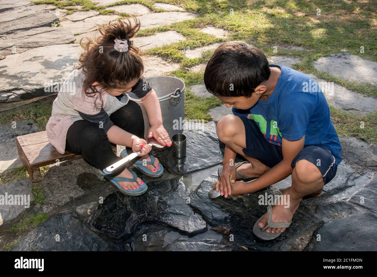 Children cleaning utensils outdoors in Shimla, Himachal Pradesh, India ...