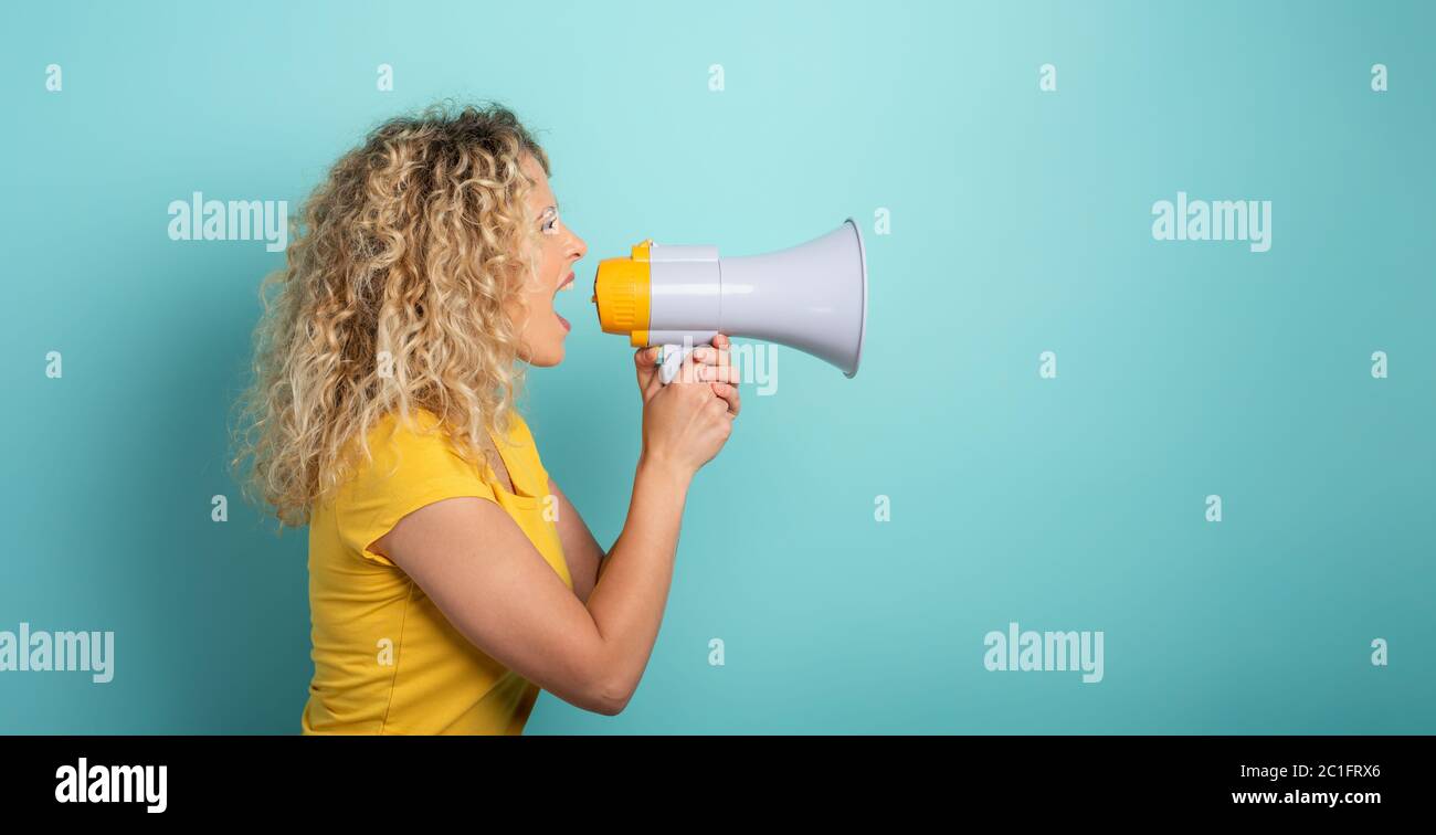 Woman screams with loudspeaker. angry expression. cyan background Stock ...