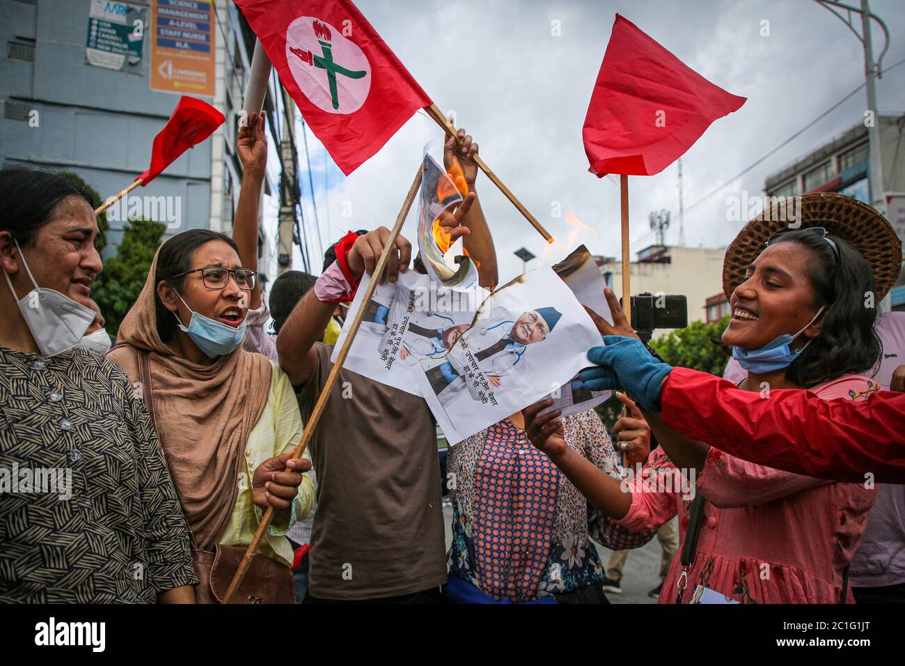 Protesters burn placards with a photo of the prime minister KP Oli ...