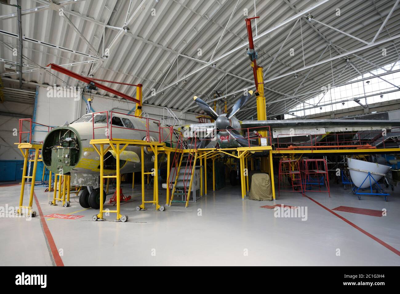 Light passenger plane standing in aircraft fixture for repair. Press ...