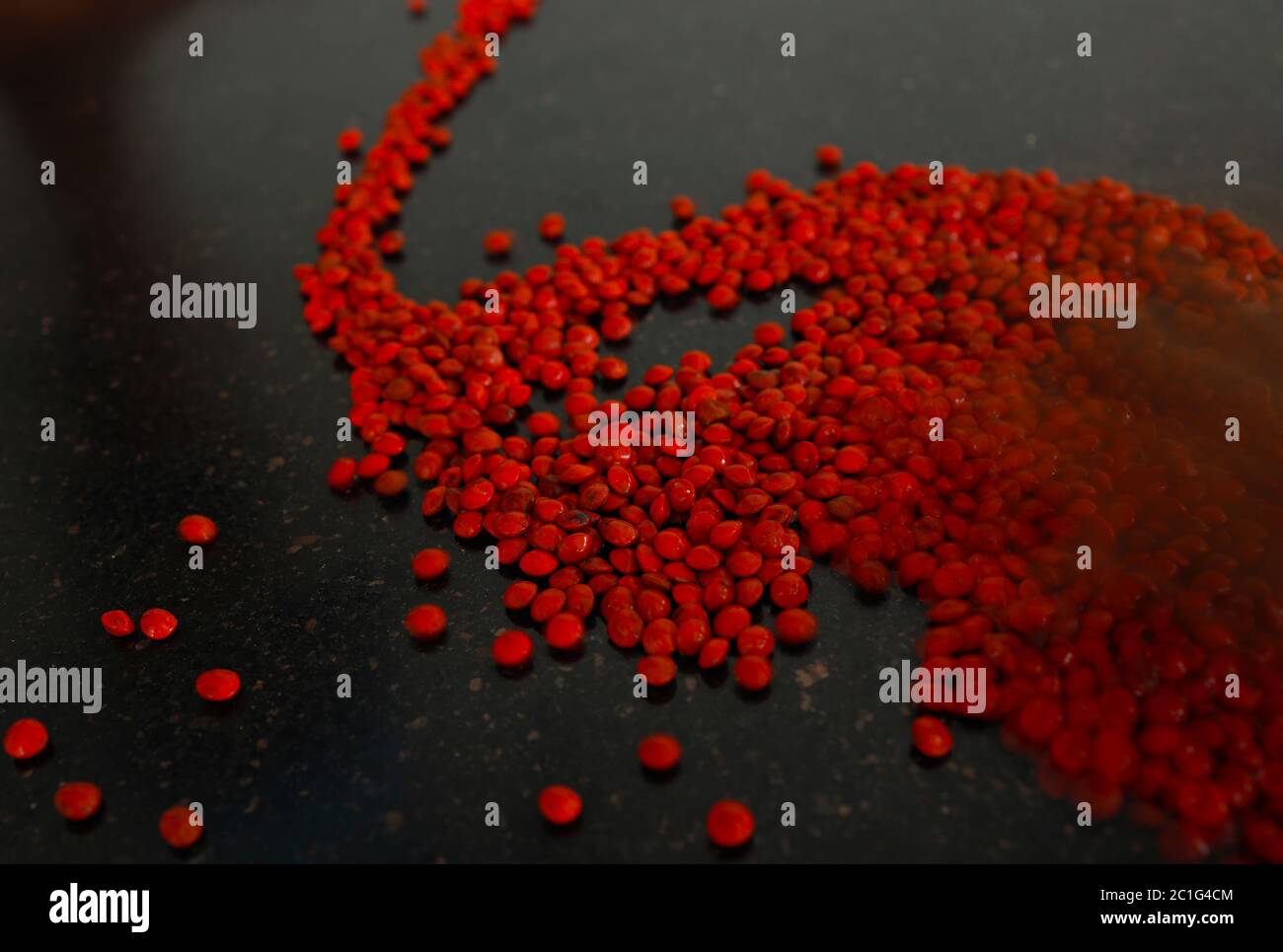 Red sandalwood (Adenanthera pavonina) seeds isolated on a black ...