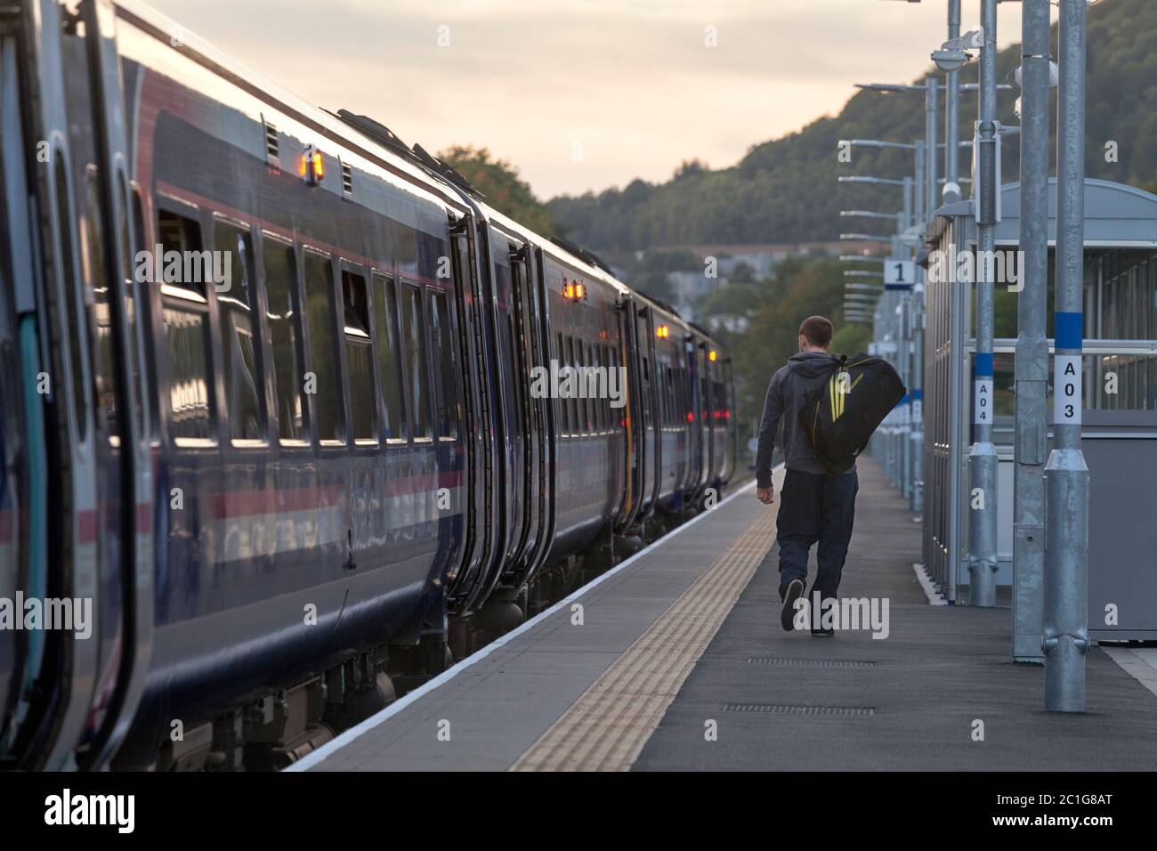 Lone railway passenger walking along the platform at Tweedbank railway ...