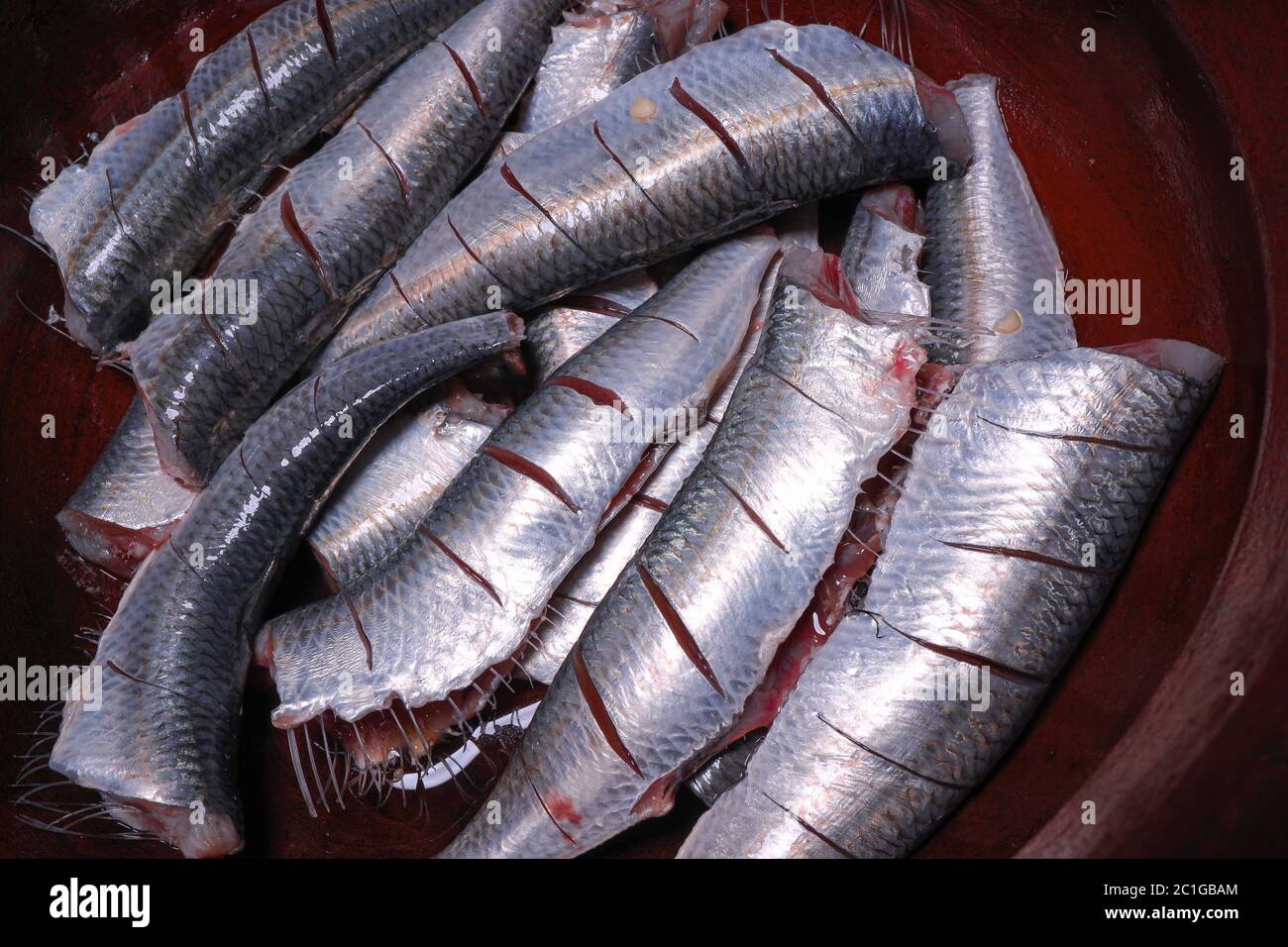 Fresh sardines cut head and being prepared for cooking south indian ...