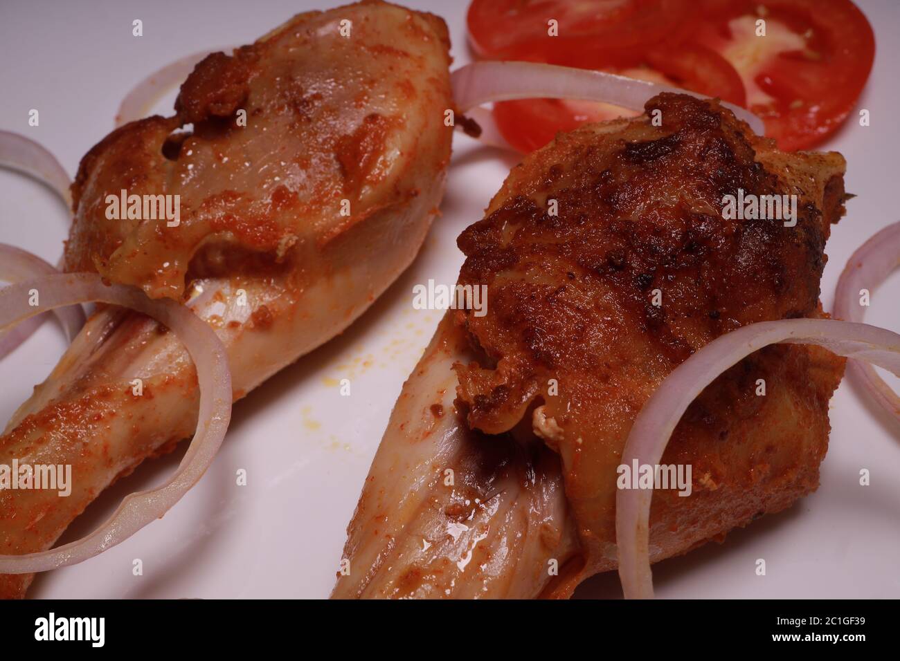 Delicious fried chicken leg served in white plate with vegetable salad ...
