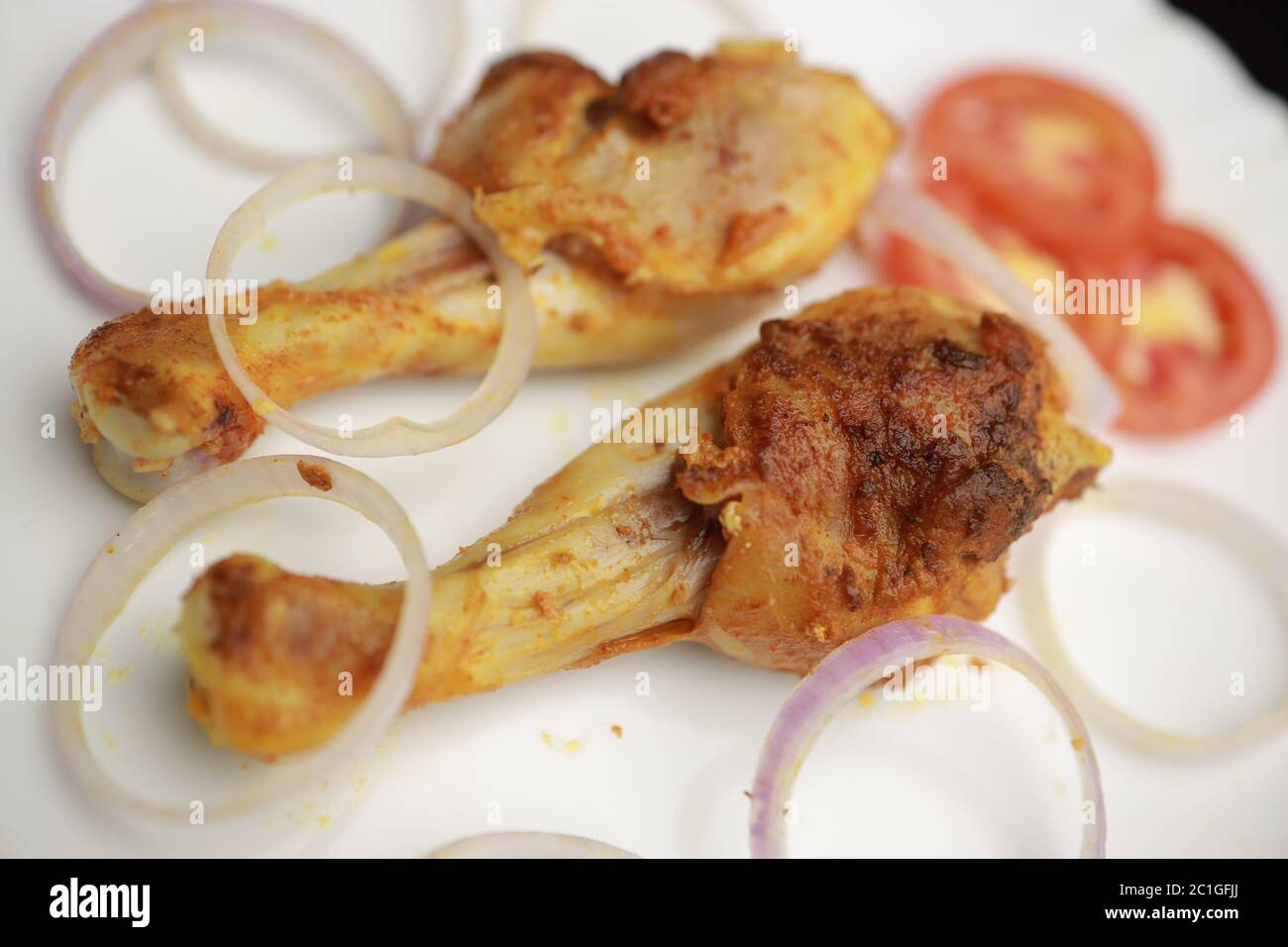 Delicious fried chicken leg served in white plate with vegetable salad ...
