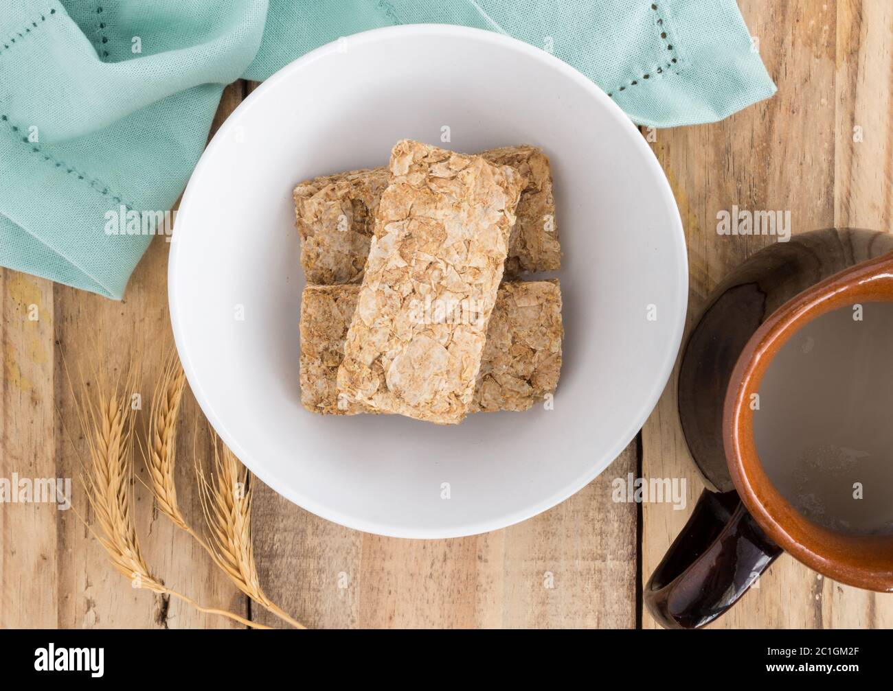 Wheat breakfast cereal raw in bowl on rustic wooden table - top view ...