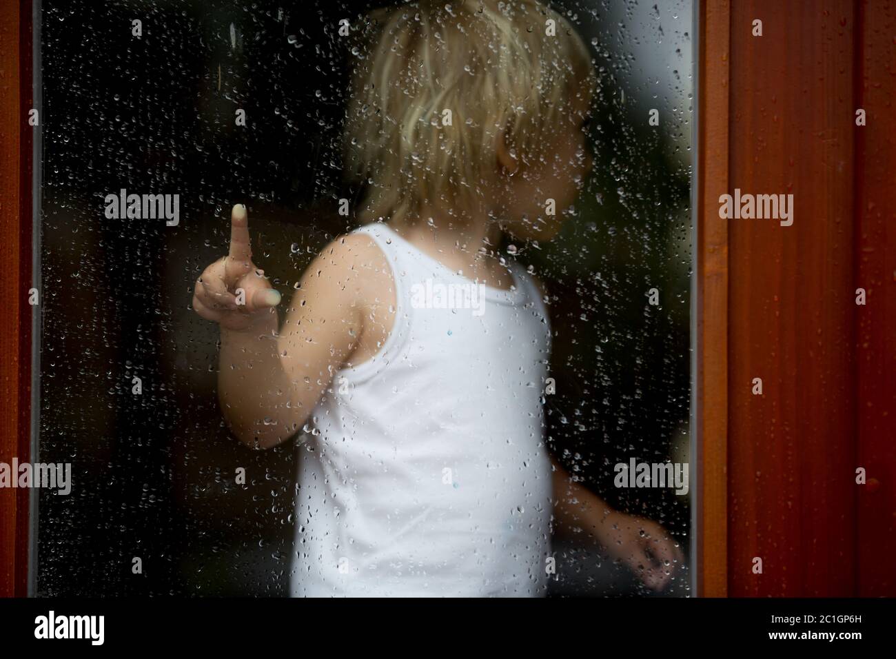 Sad child behind the window on a rainy day Stock Photo - Alamy