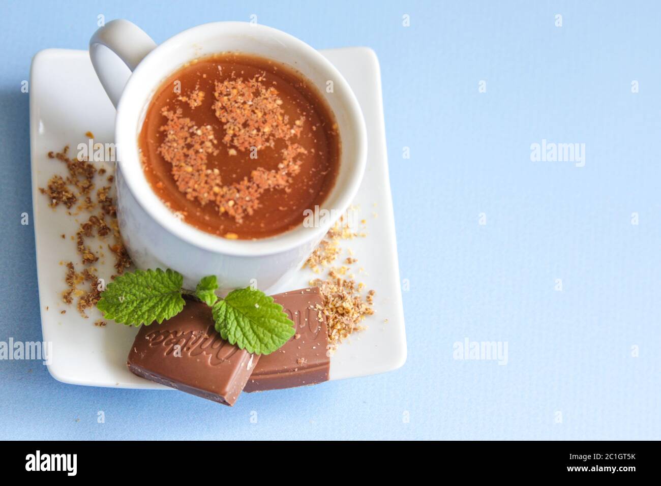 Milk chocolate Milka with a fresh mint leaf and a cup of hot cacao ...