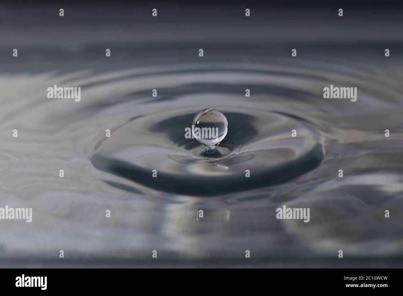 A small water drop fall on water surface Stock Photo - Alamy