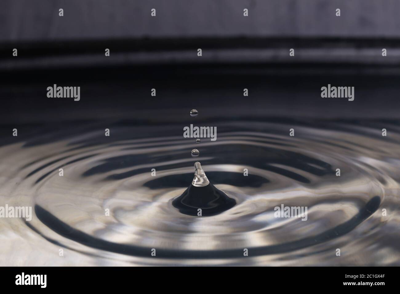 A small water drop fall on water surface Stock Photo - Alamy