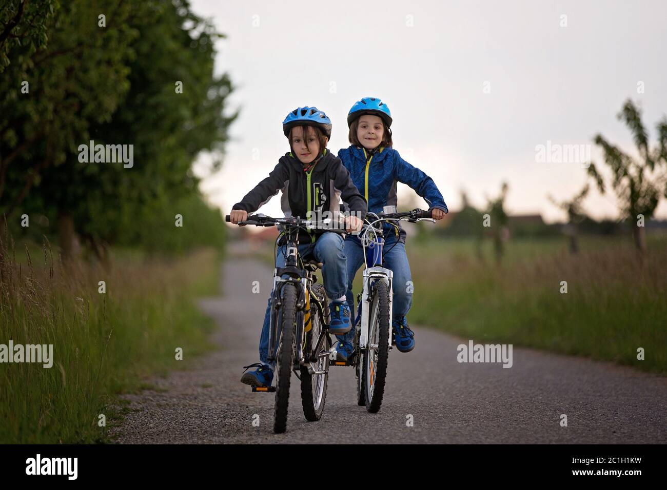 Children, boys, riding bikes together summer time on a rainy day Stock ...