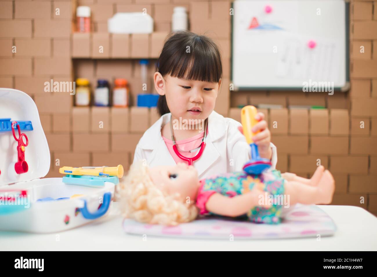 toddler girl pretend play doctor role at home Stock Photo - Alamy