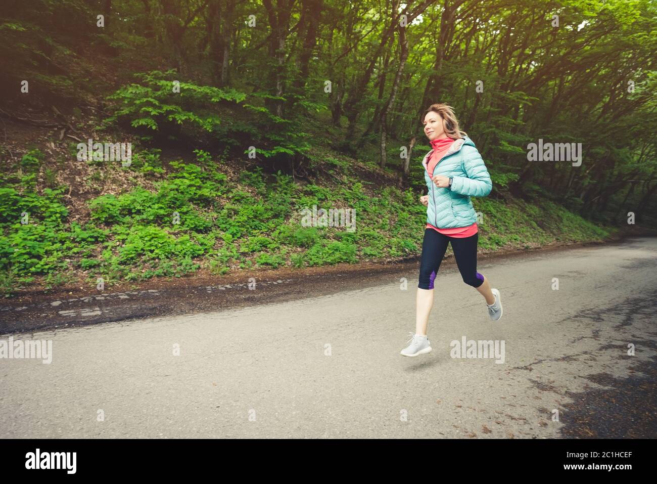 Young fitness blonde woman in headphones running at morning caucasian ...