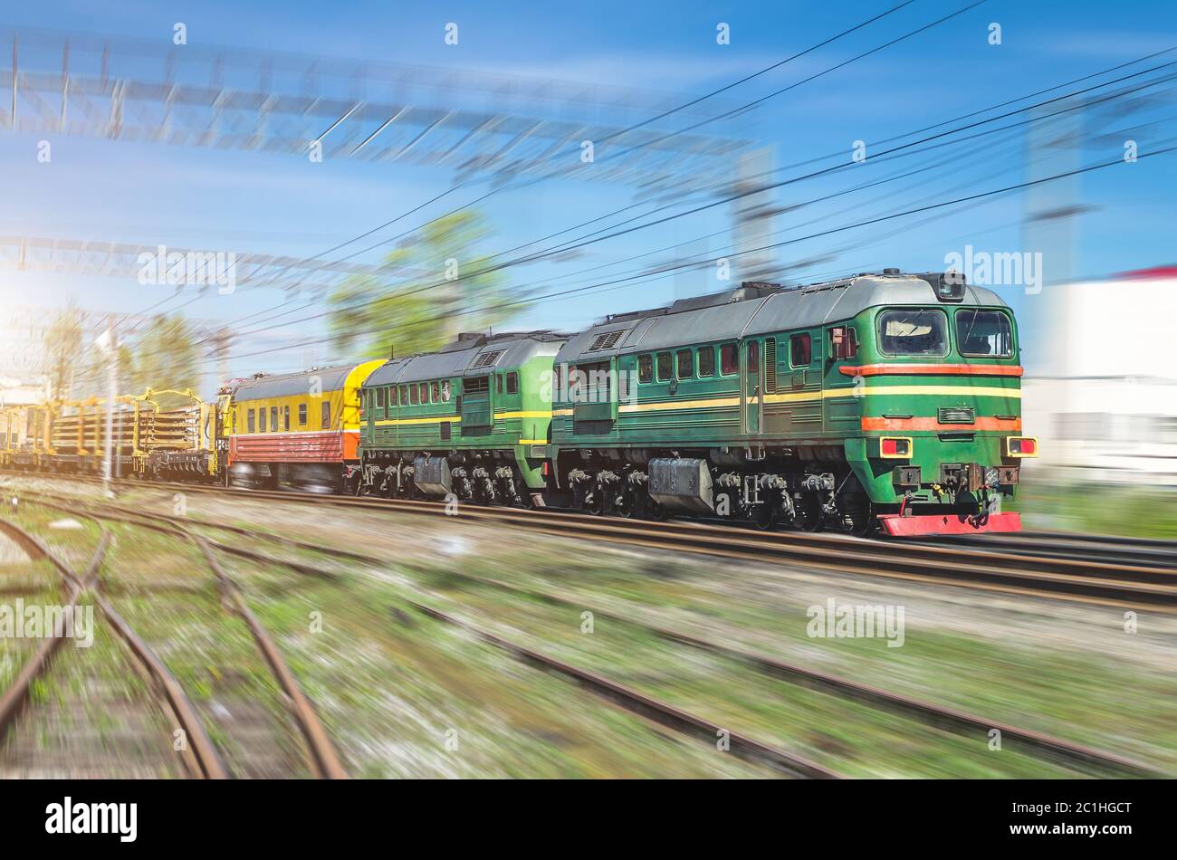 Double freight train green locomotive and on the forks of the railway ...