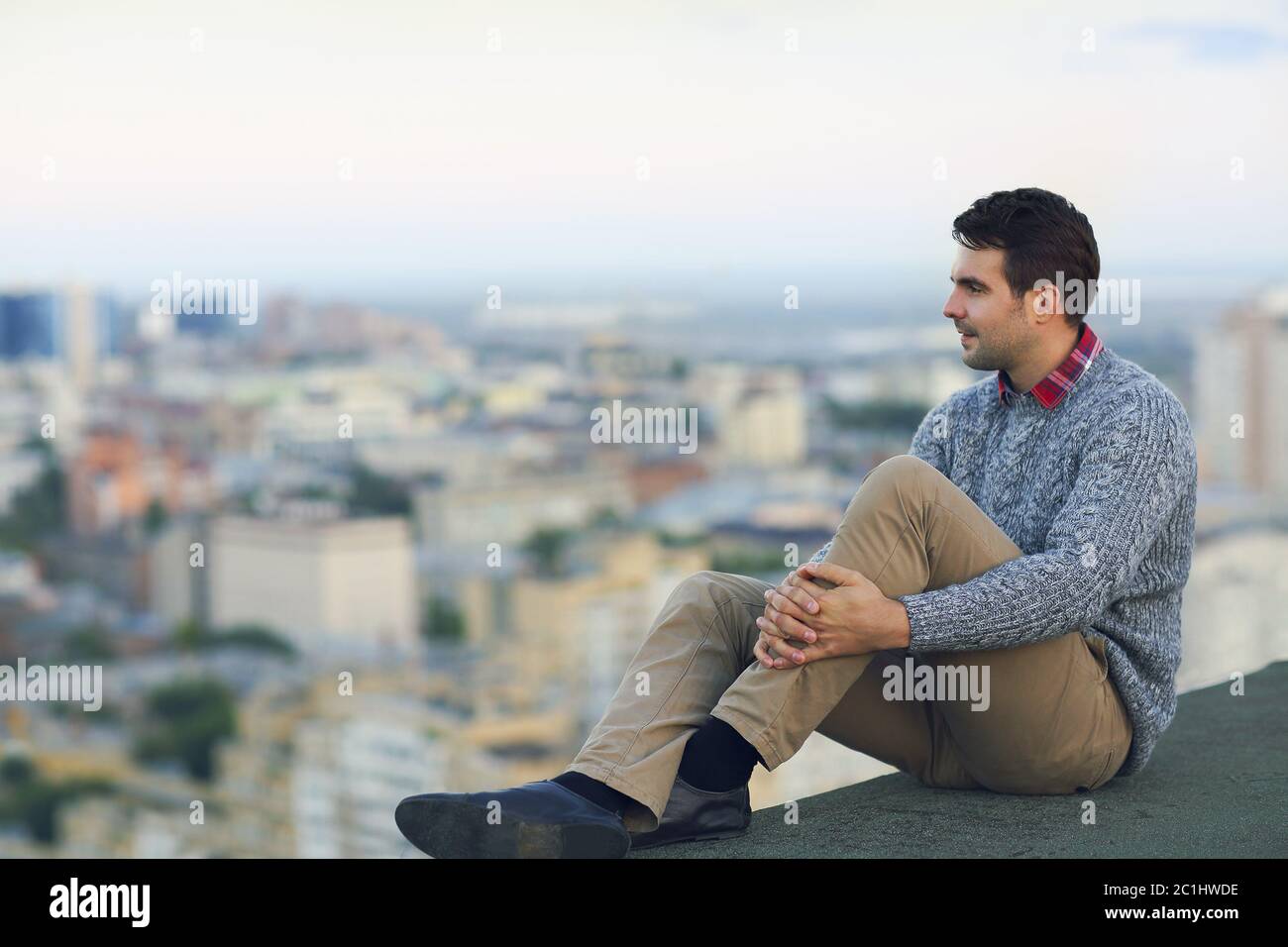 Smiling man sitting roof hi-res stock photography and images - Alamy