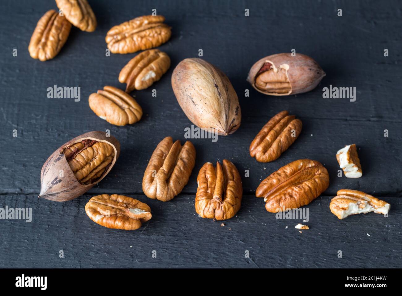 Pecan nut background with pecan nuts close up on rustic black table ...