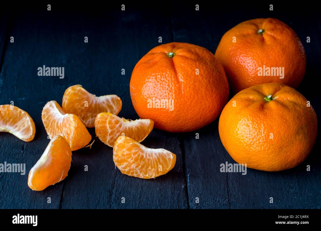 Tangerines on rustic black table close up - Citrus fruit background ...
