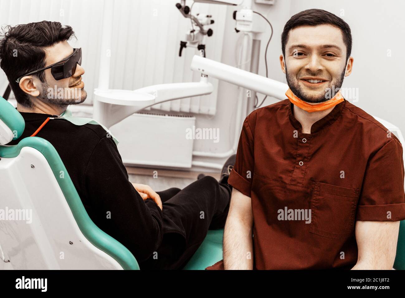 A young dentist discusses a diagnosis and treatment plan with a patient ...