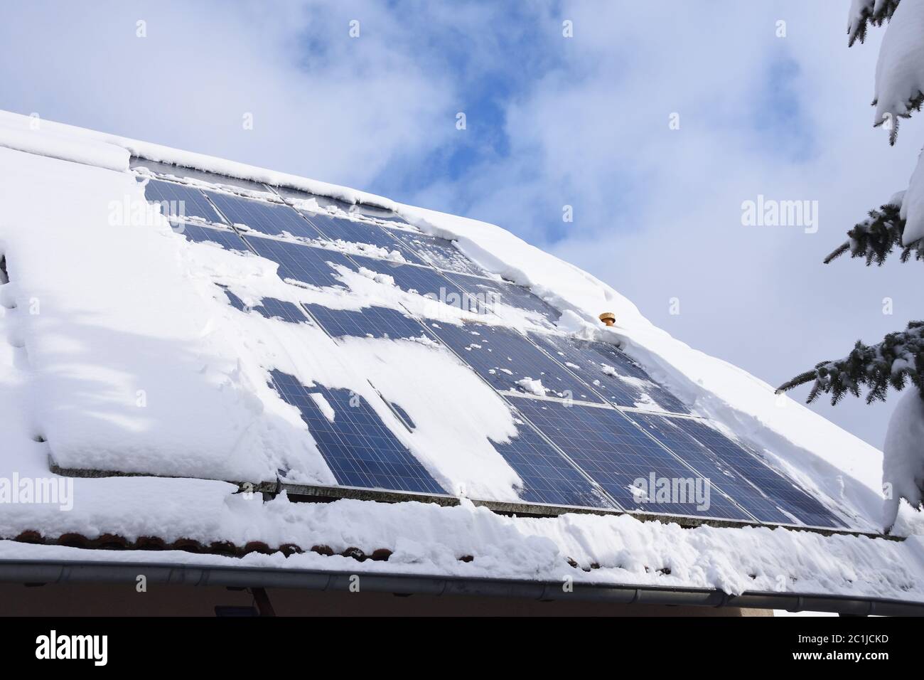 Snow-covered solar system on a house in winter Stock Photo - Alamy