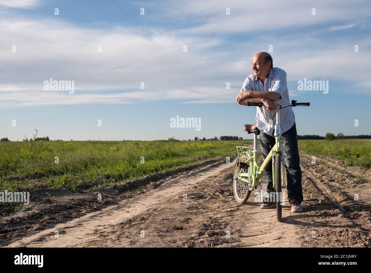 Old man riding a bike on field resting on the sunny day Stock Photo - Alamy